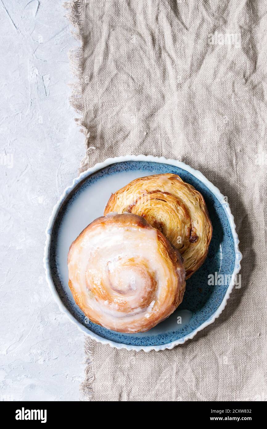 Homemade glazed puff pastry cinnamon rolls with custard and raisins on ...