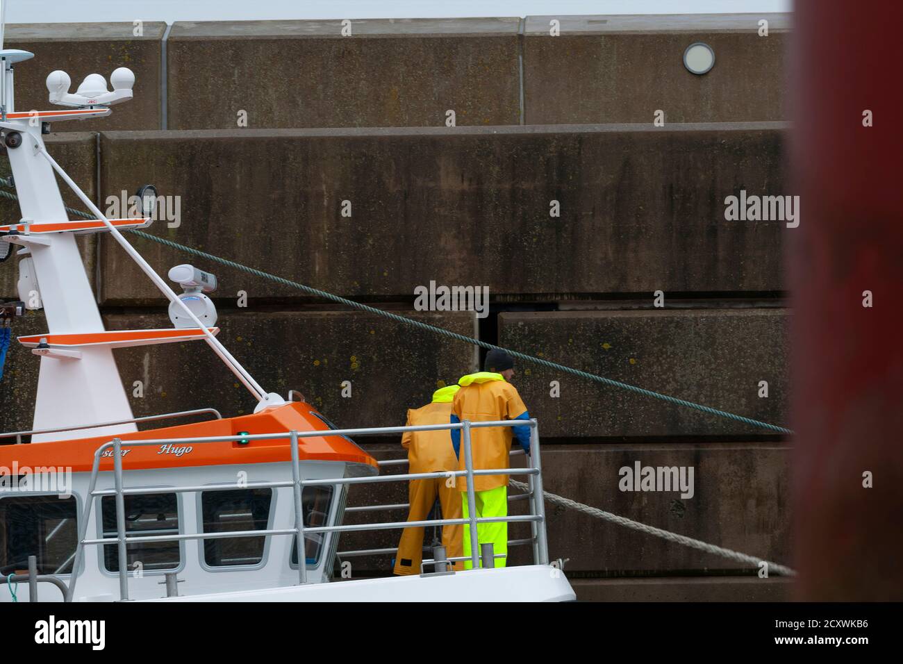 Ropework. Crew of fishing boat working with mooring line Stock Photo ...