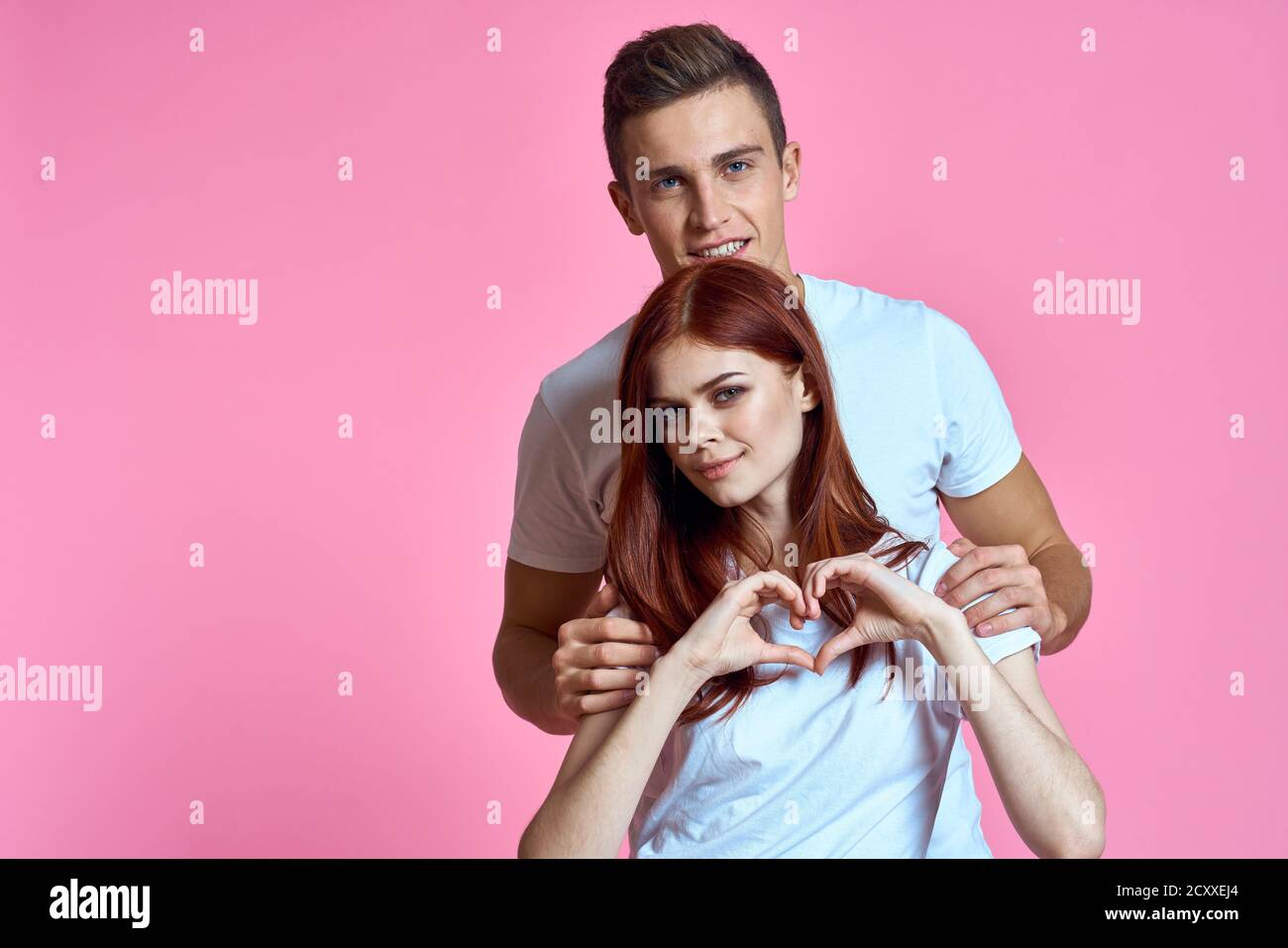 enamored man and woman hugging each other on a pink background cropped ...
