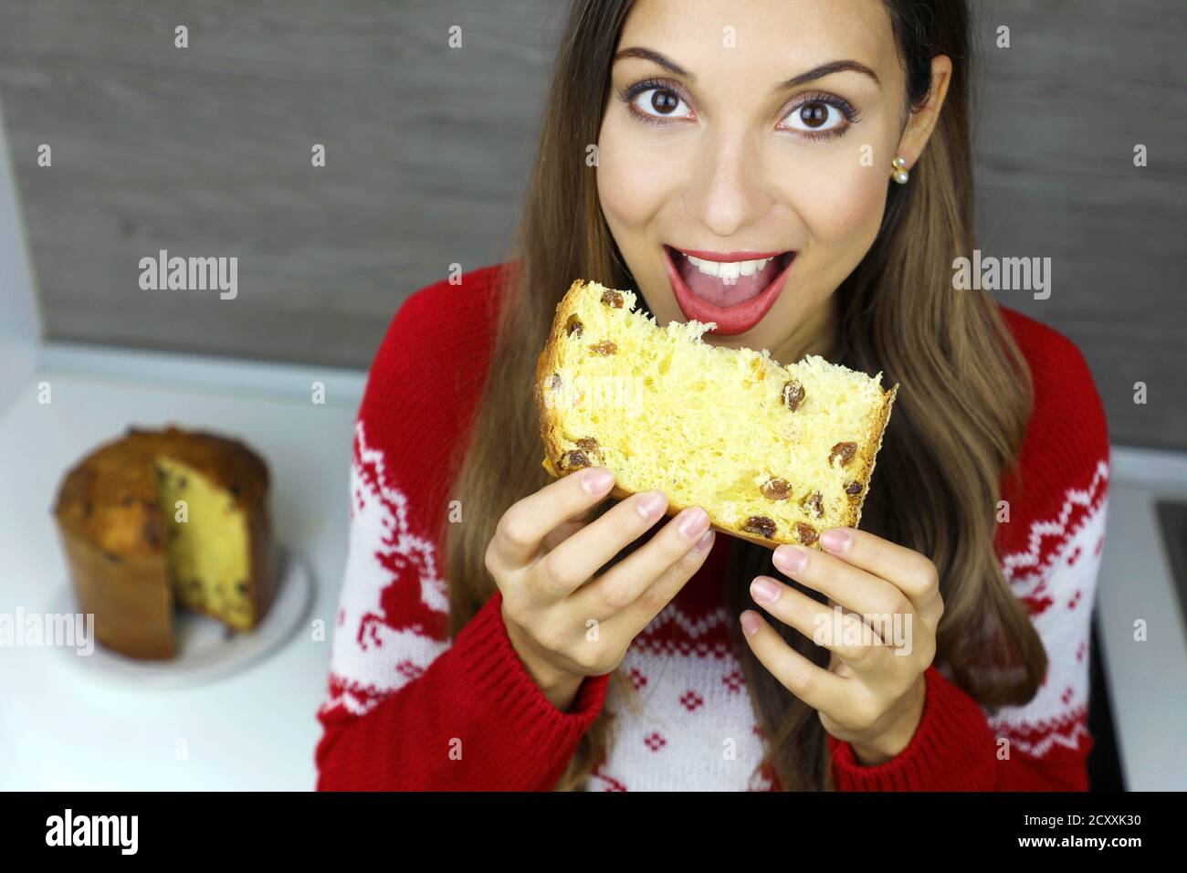 Close up from above of young woman eating a slice of Panettone ...