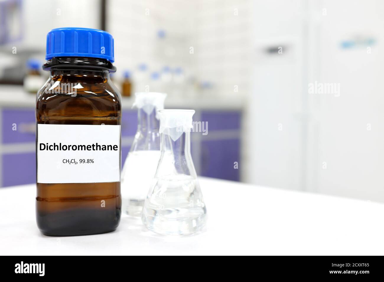 Selective focus of dichloromethane liquid chemical compound in dark glass bottle inside a ...