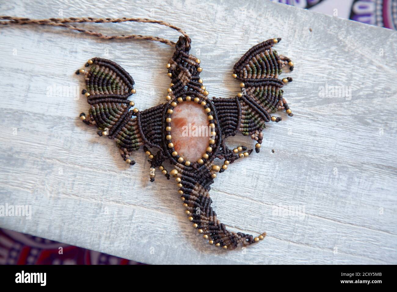 Macrame technique waxed string necklace with gemstone in the shape of dragon Stock Photo - Alamy
