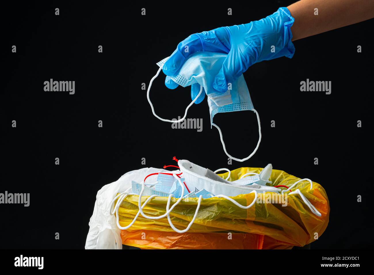 Hand putting used dirty surgical mask to a garbage bin Stock Photo - Alamy