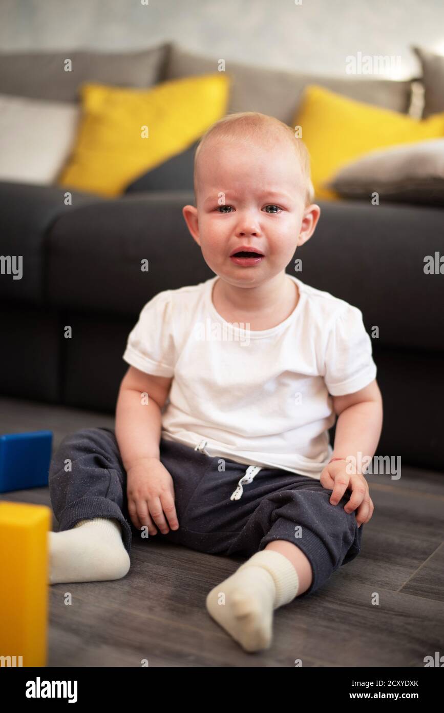 Little unhappy child crying on the floor in his room Stock Photo - Alamy