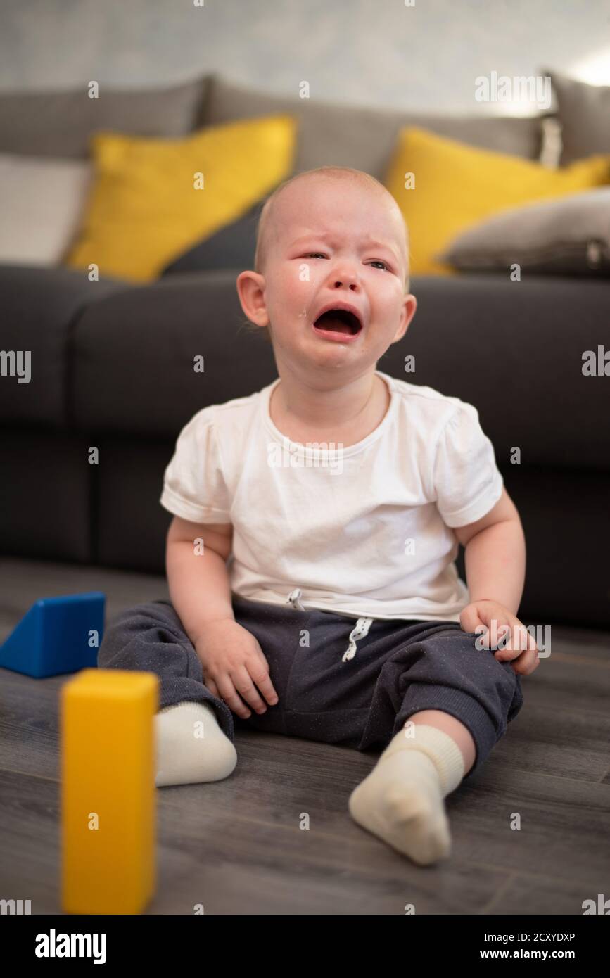 Little unhappy child crying on the floor in his room Stock Photo - Alamy