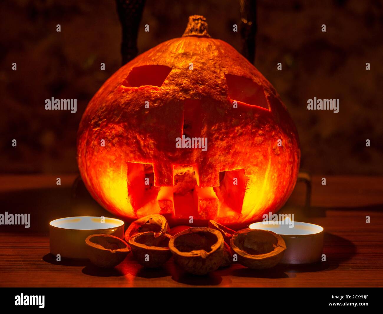 Halloween theme - pumpkin and walnut shells in the dark, lit by two ...