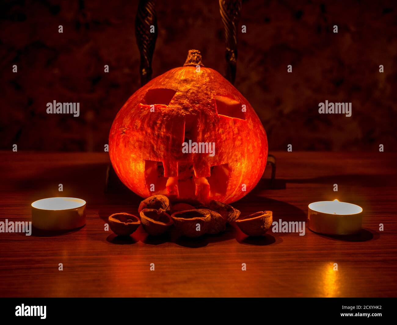 Halloween theme - pumpkin and walnut shells in the dark, lit by candles ...