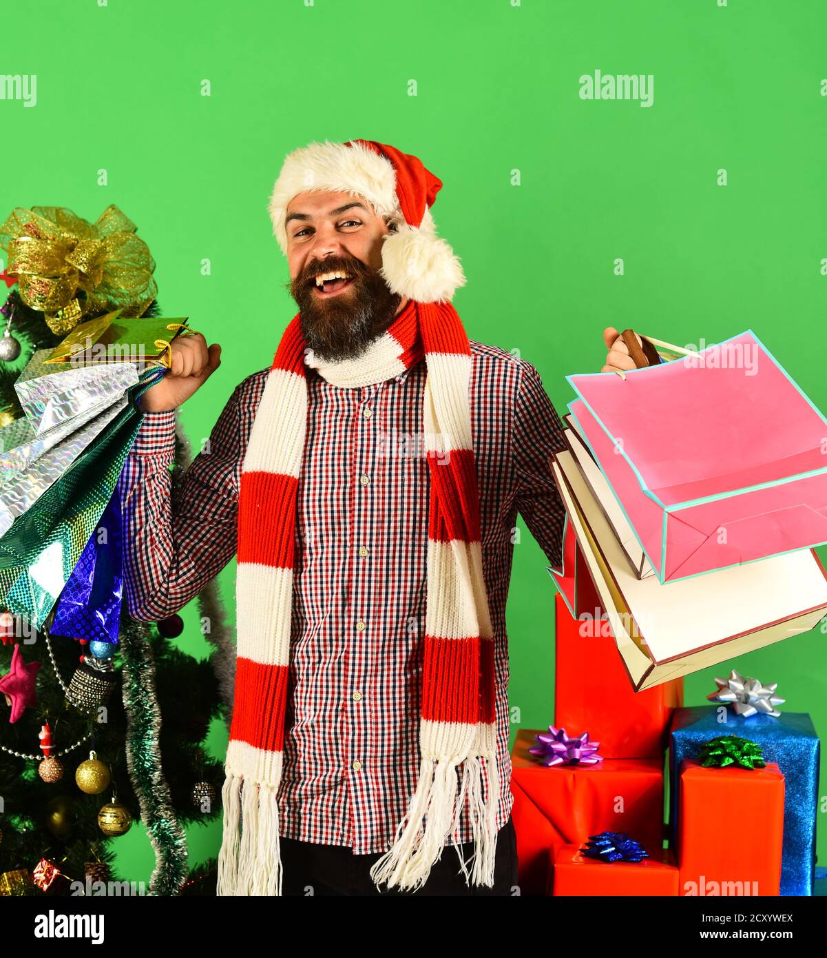 Man with beard and cheerful face on green background. Guy in red hat ...