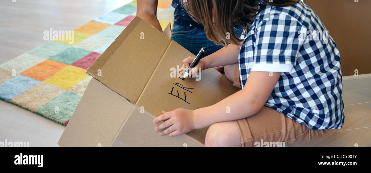 Boy writing in a moving box Stock Photo - Alamy