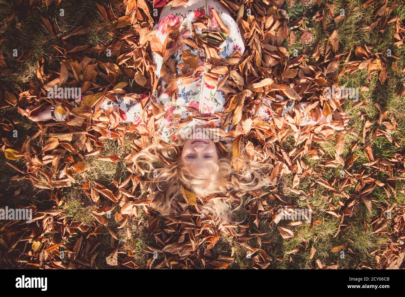view from birds eye perspective to lovely blond girl lying among leaves ...