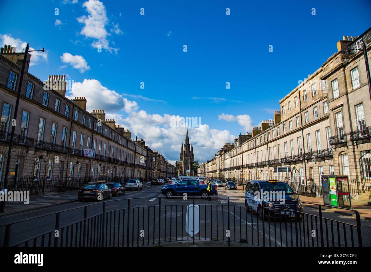 Symmetrical street with old buildings full of windows and church in th ...