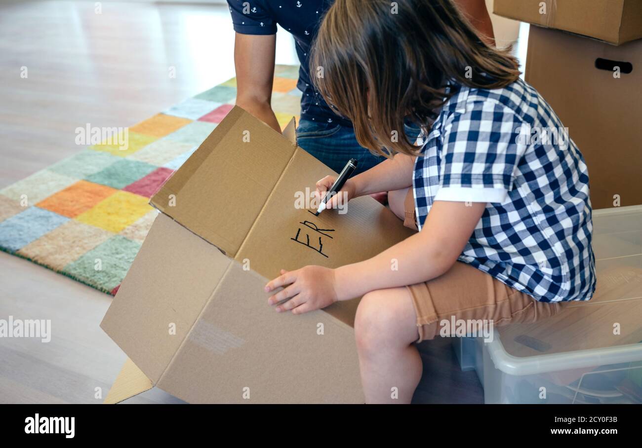 Boy writing in a moving box Stock Photo - Alamy
