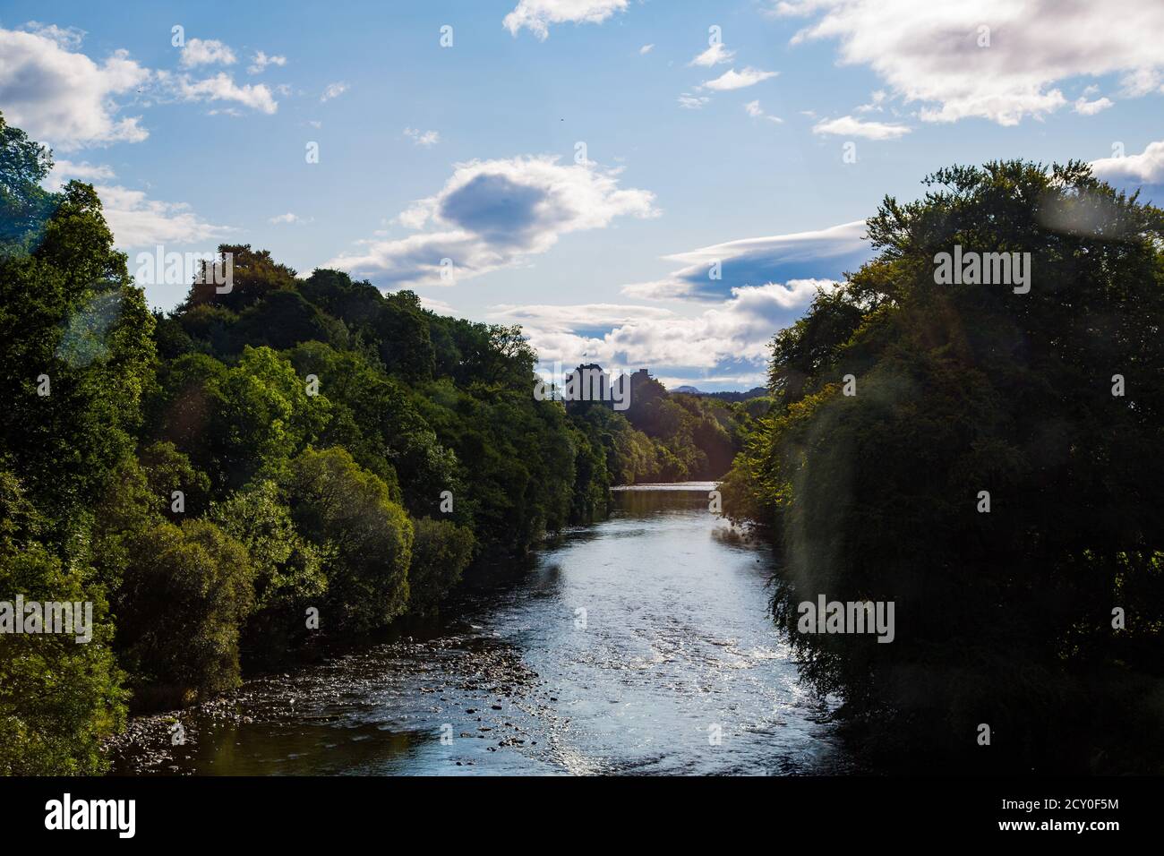 River flowing between lines of trees and castle in the background Stock ...
