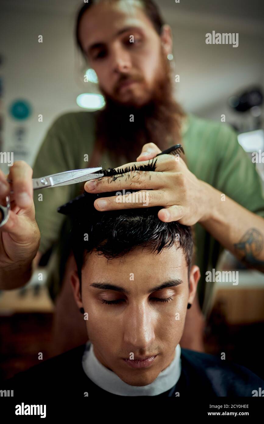 Close-up of a young man having his hair cut off. Barber concept Stock ...