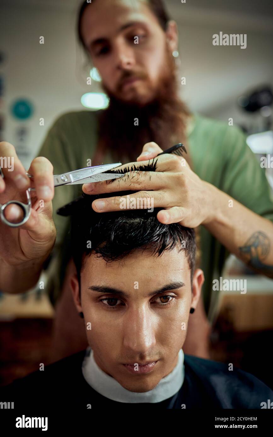 Close-up of a young man having his hair cut off. barber concept Stock ...