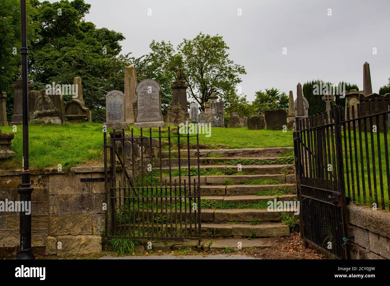 Entrance of metal fence and staircase to cemetery Stock Photo - Alamy