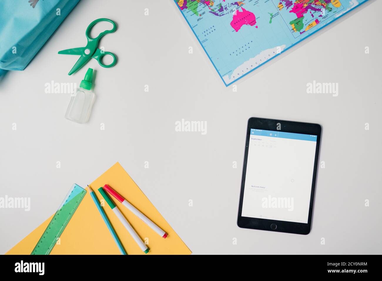 distance learning materials with tablet, map, markers, scissors, glue ...