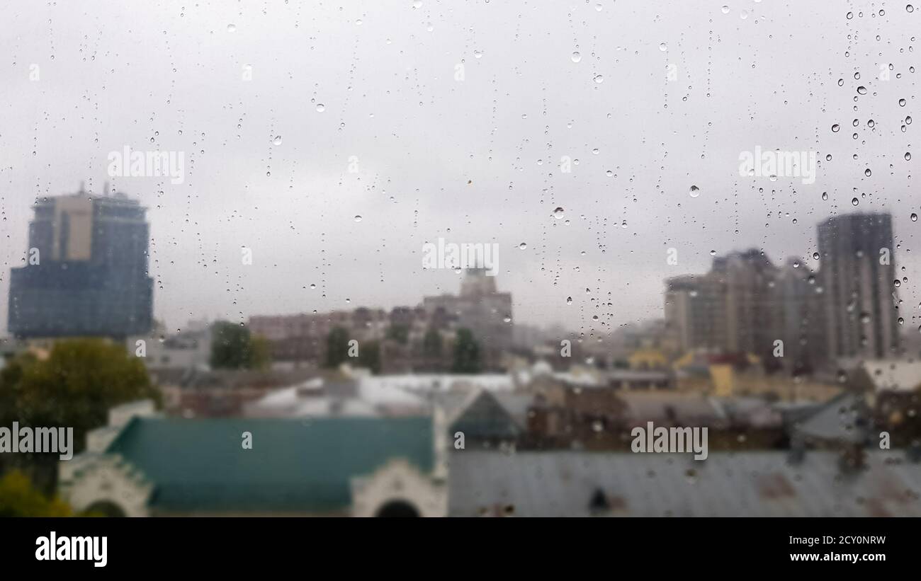 Wet window with drops on the background of the autumn city in cloudy ...