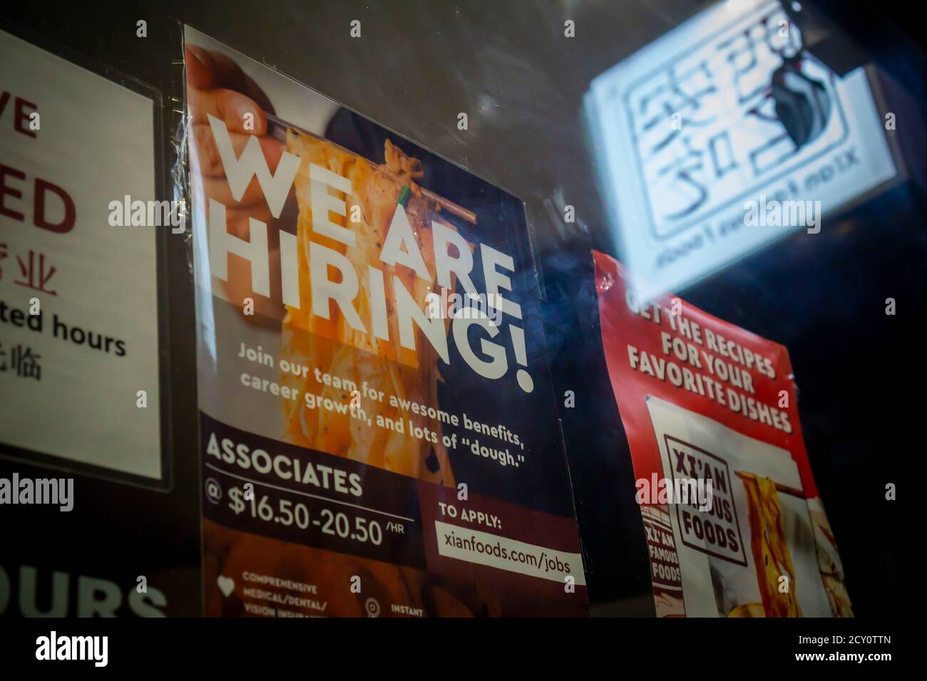 A “We’re Hiring " sign in the window of a restaurant in Chelsea in New ...