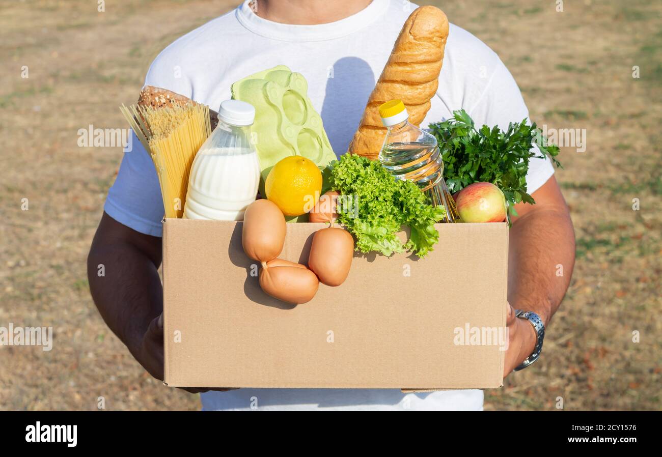 Delivery man holding box with fresh food groceries outdoors Stock Photo ...