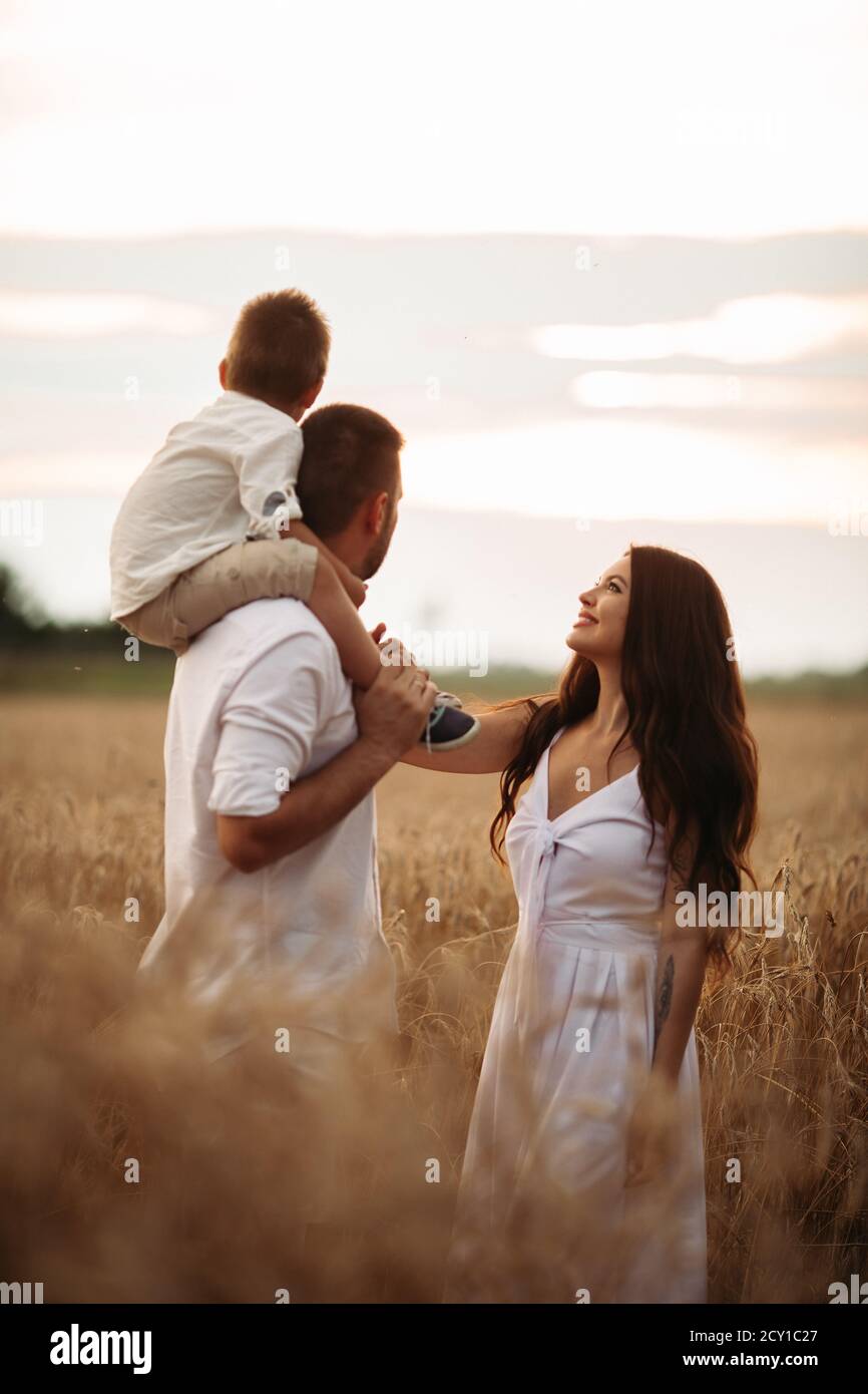 Beautiful mum, dad and their cute little child have fun together and ...