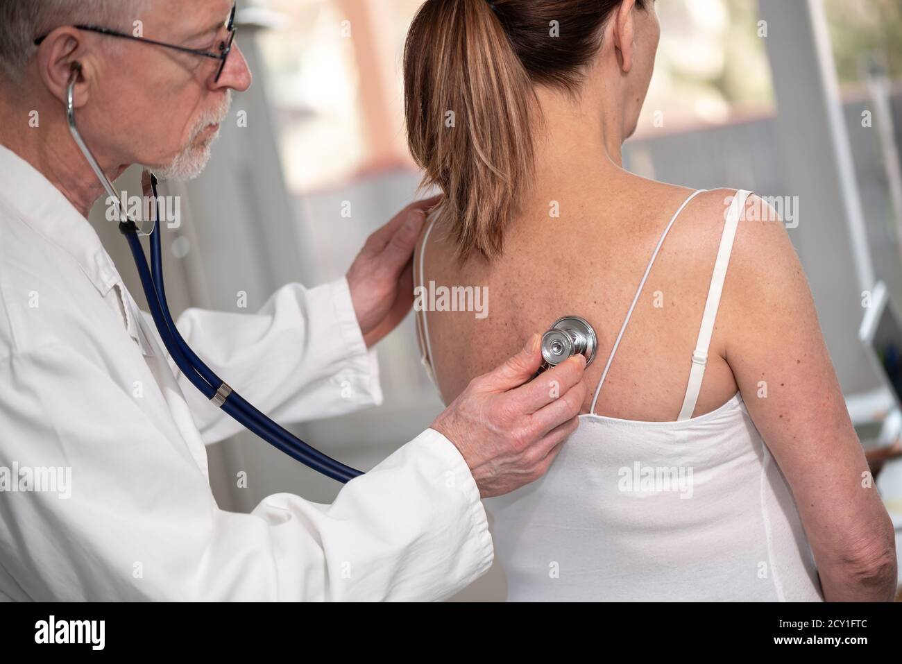 Senior doctor auscultating his female patient with stethoscope Stock ...
