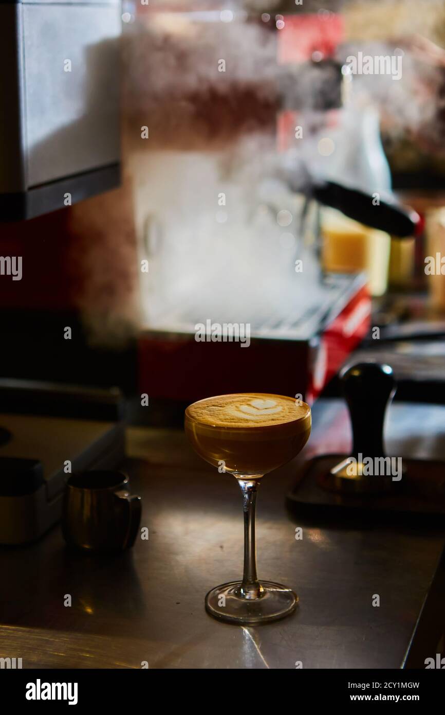 Cafe Latte or coffee Piccolo with heart shape of latte art in a martini ...