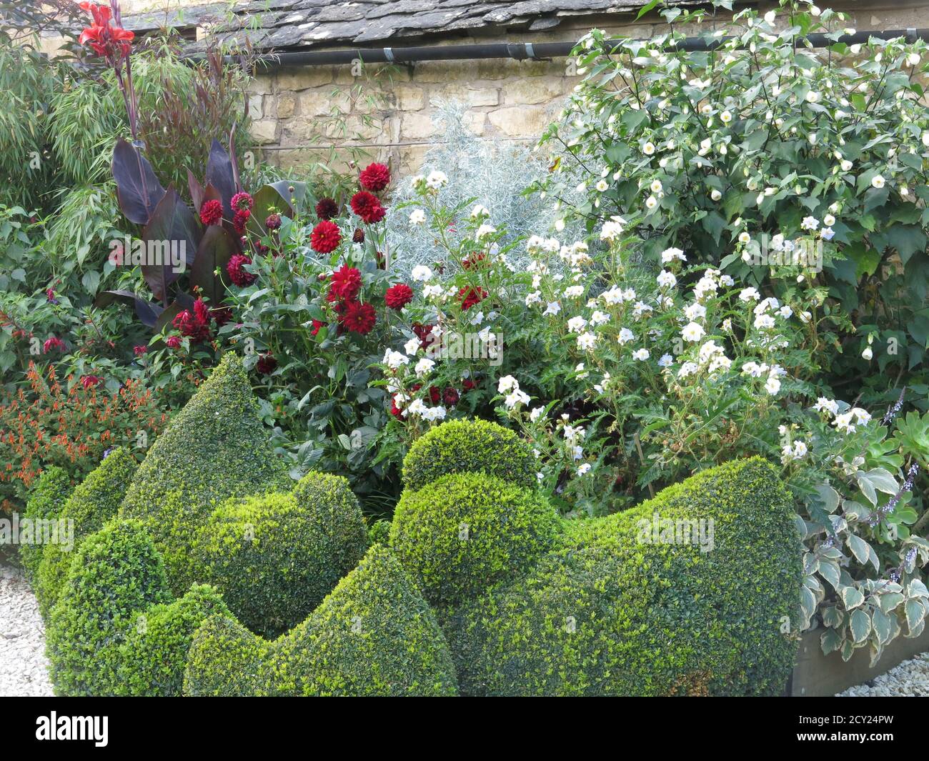 Topiary chickens and colourful planting in the courtyard of the award ...