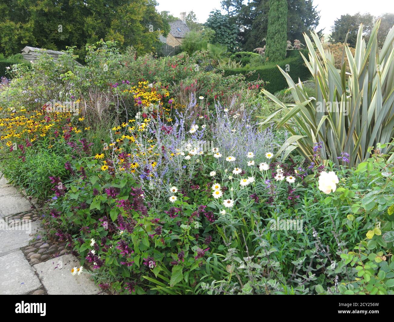 A richly planted flower border in the gardens at Bourton House; an ...