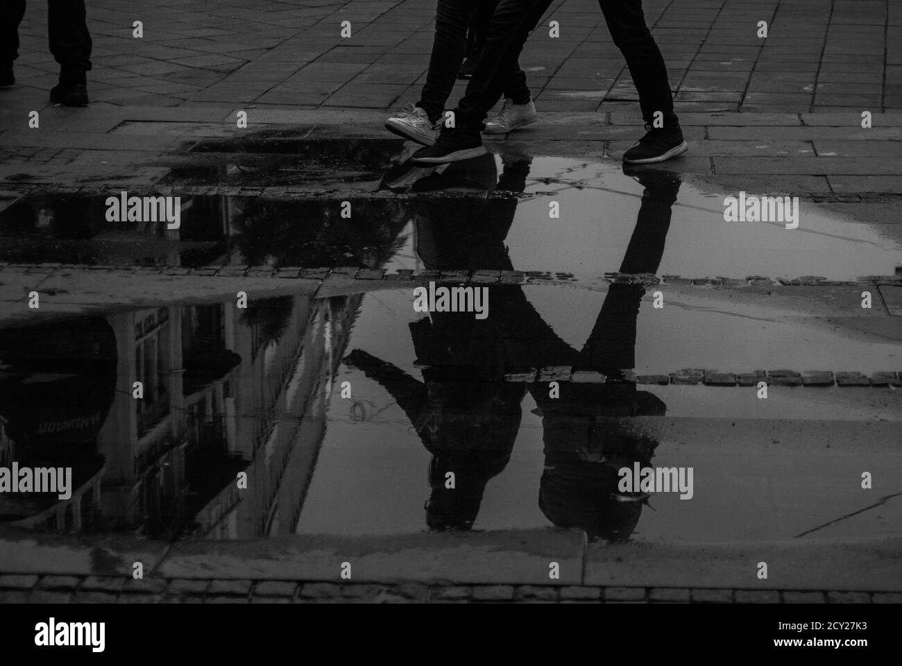Couple reflected on a puddle Stock Photo - Alamy