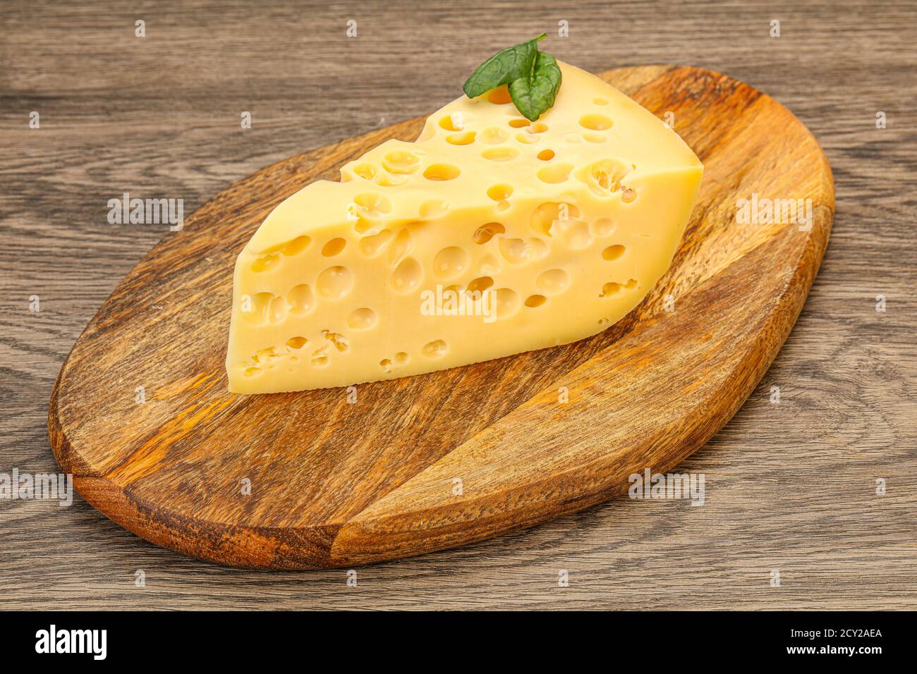 Maasdam cheese - dairy yellow triangle with holes Stock Photo - Alamy