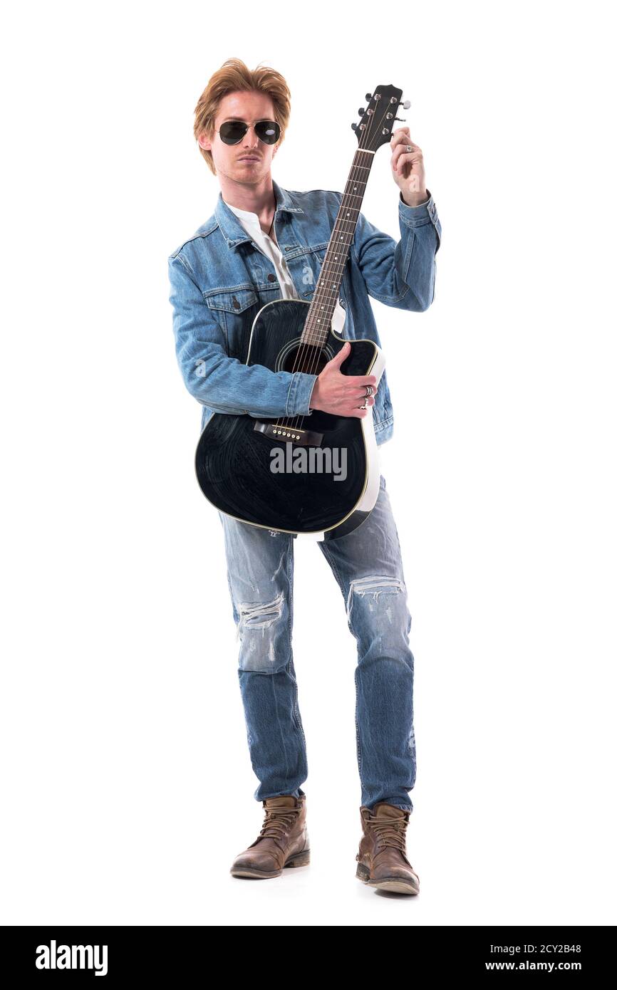Handsome young stylish guitarist getting ready tuning acoustic guitar ...