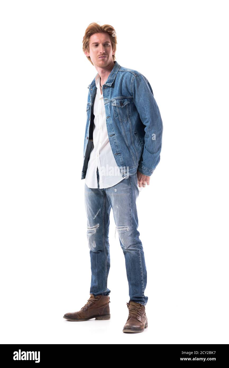 Satisfied young stylish man in jeans looking back over shoulder and ...