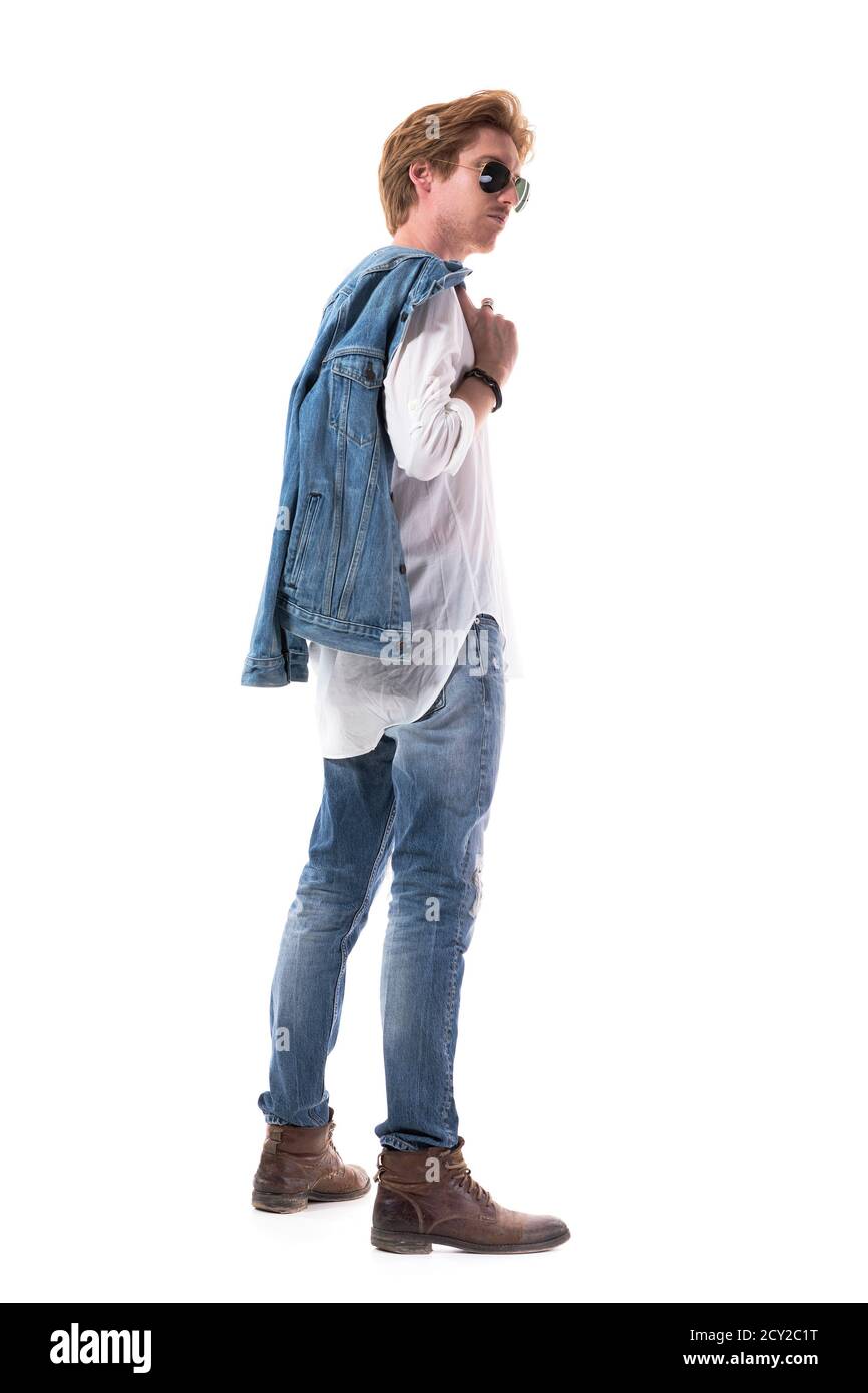 Side view of serious stylish young man with sunglasses watching at ...
