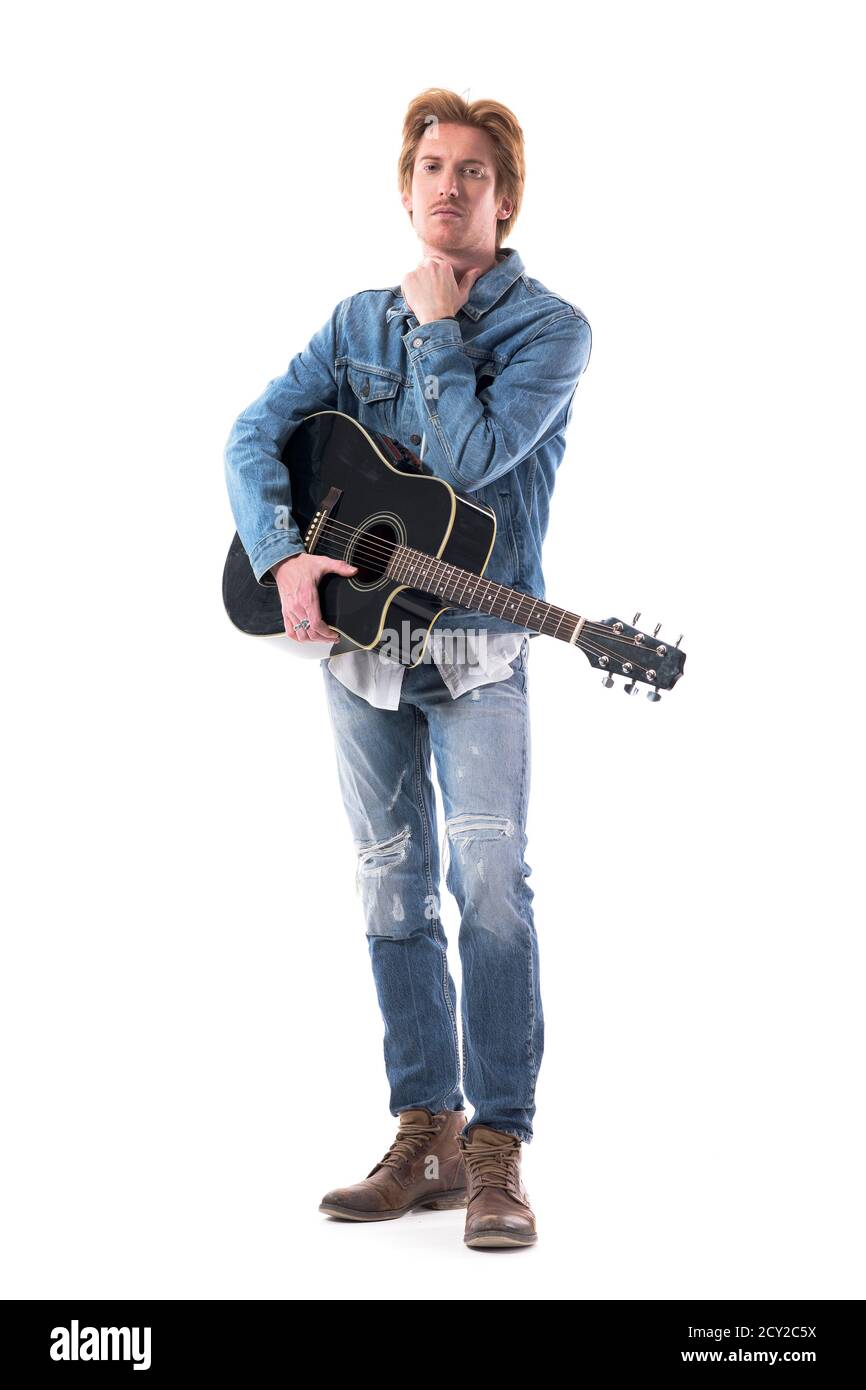Handsome stylish rocker posing with acoustic guitar looking at camera ...