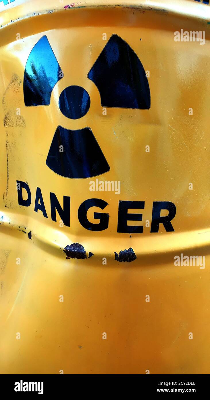 Distorted caution symbol of nuclear threat on yellow painted rusty ...