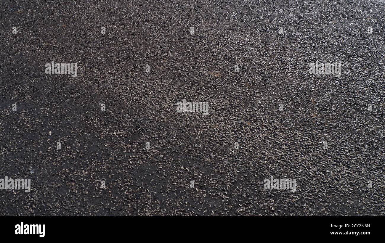 A road paved with tar, asphalt road made of small pebble stones Stock ...
