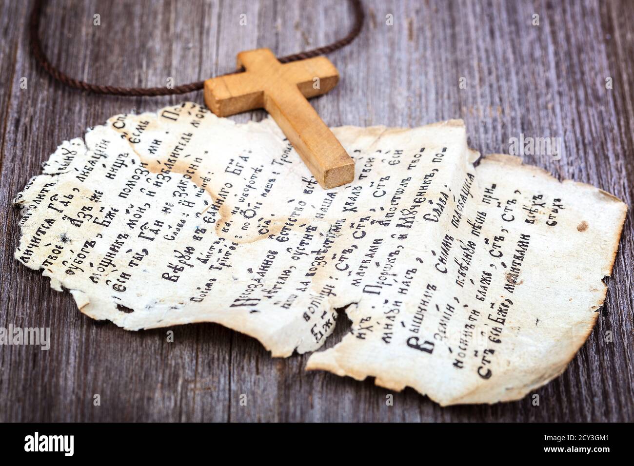 A piece of the page of an ancient holy book is a wooden cross Stock ...