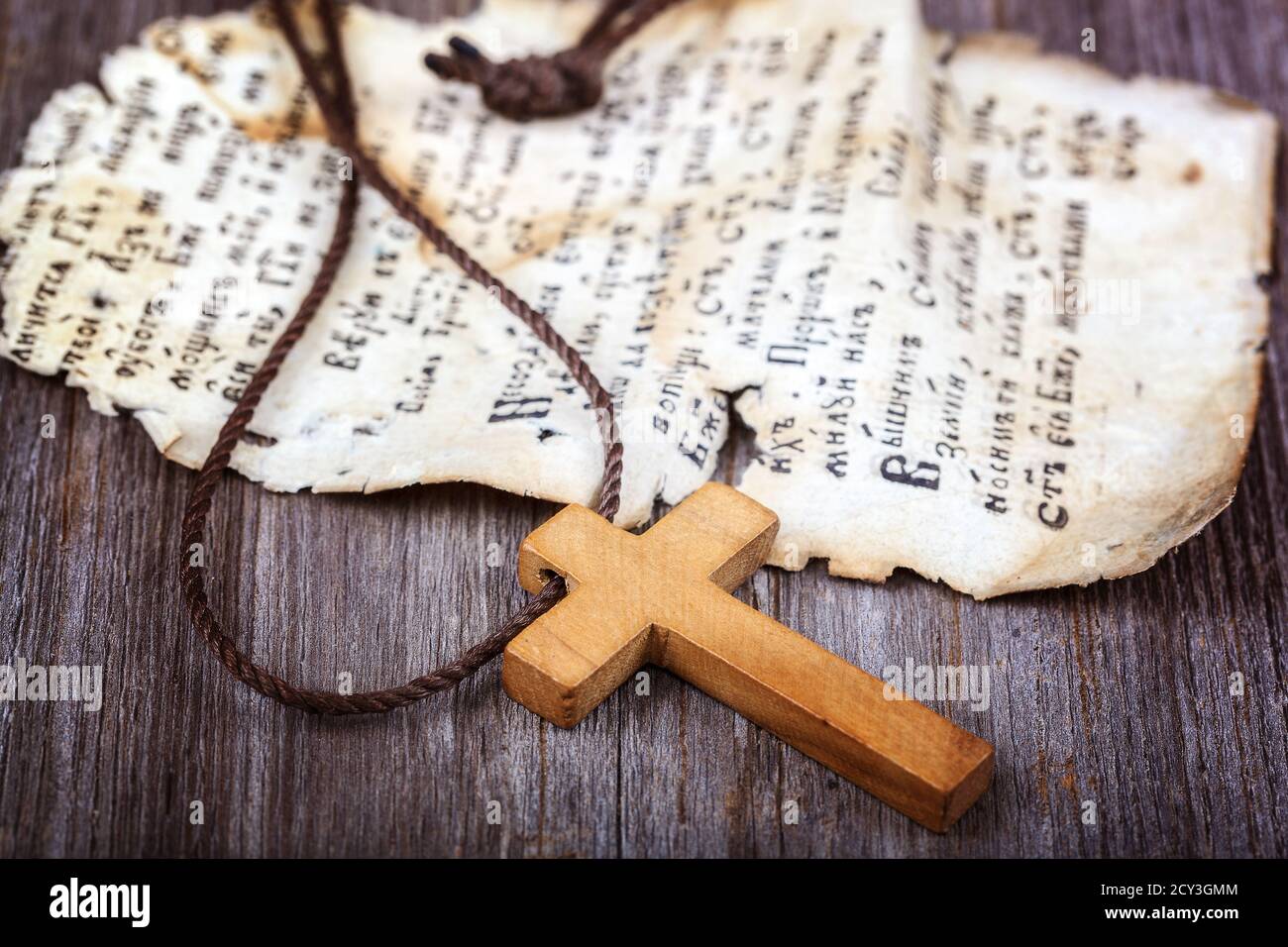 A piece of the page of an ancient holy book is a wooden cross Stock ...