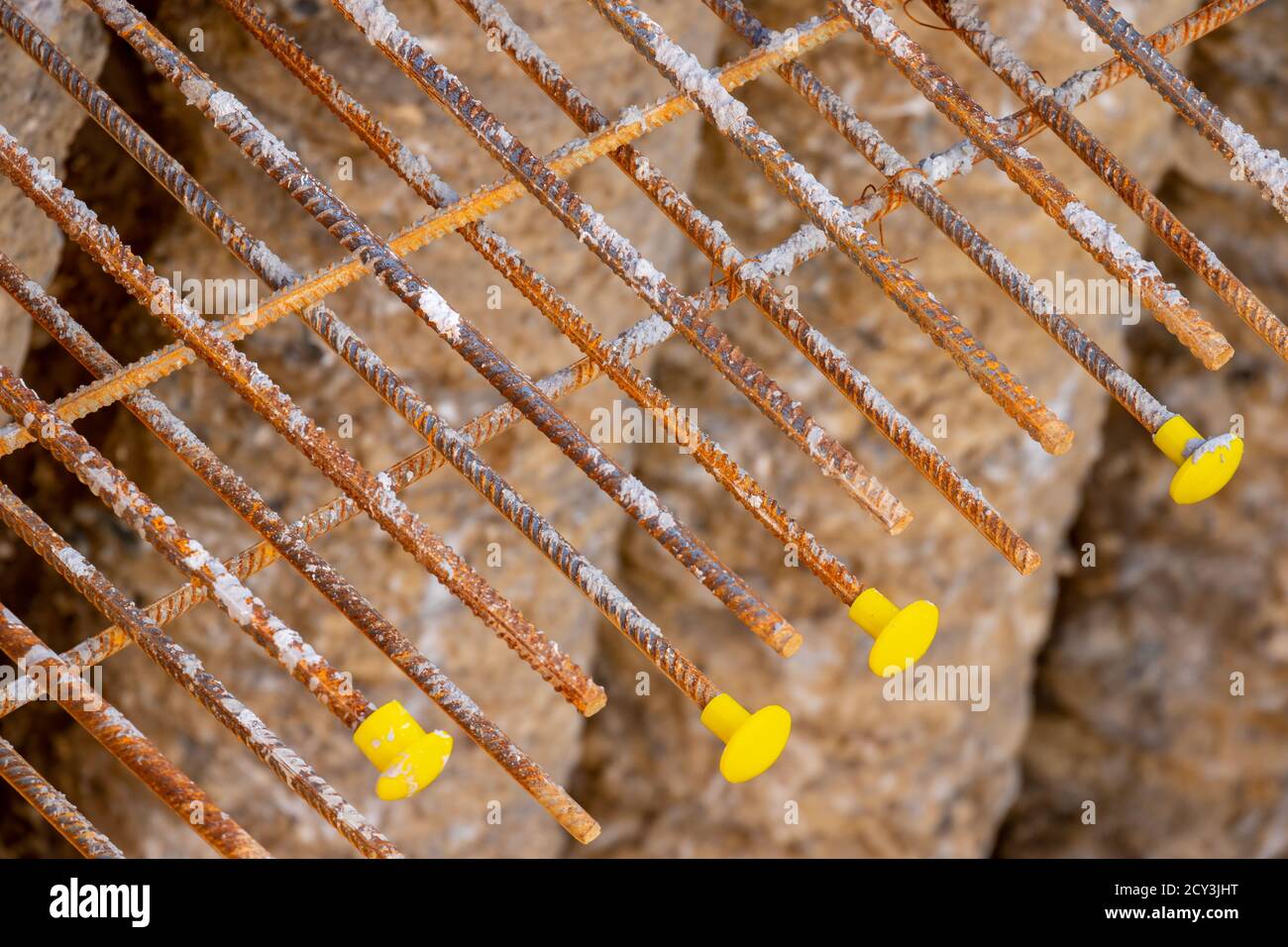 Rusty steel threaded rods bars with yellow protection caps. Covers ...