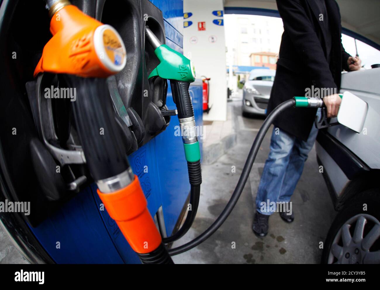 Customer fills her car with petrol at petrol station hi-res stock ...