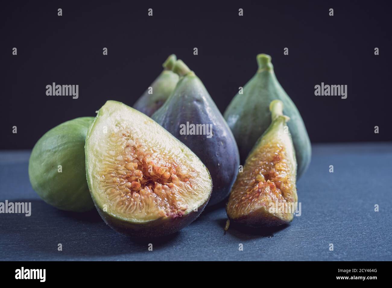 Fresh figs on a dark slate table with black background. Free space for ...