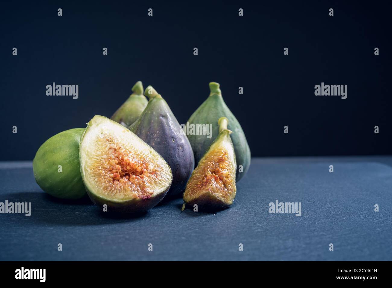 Fresh figs on a dark slate table with black background. Free space for ...