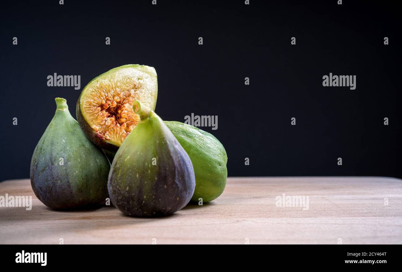 Fresh figs on a dark slate table with black background. Free space for ...