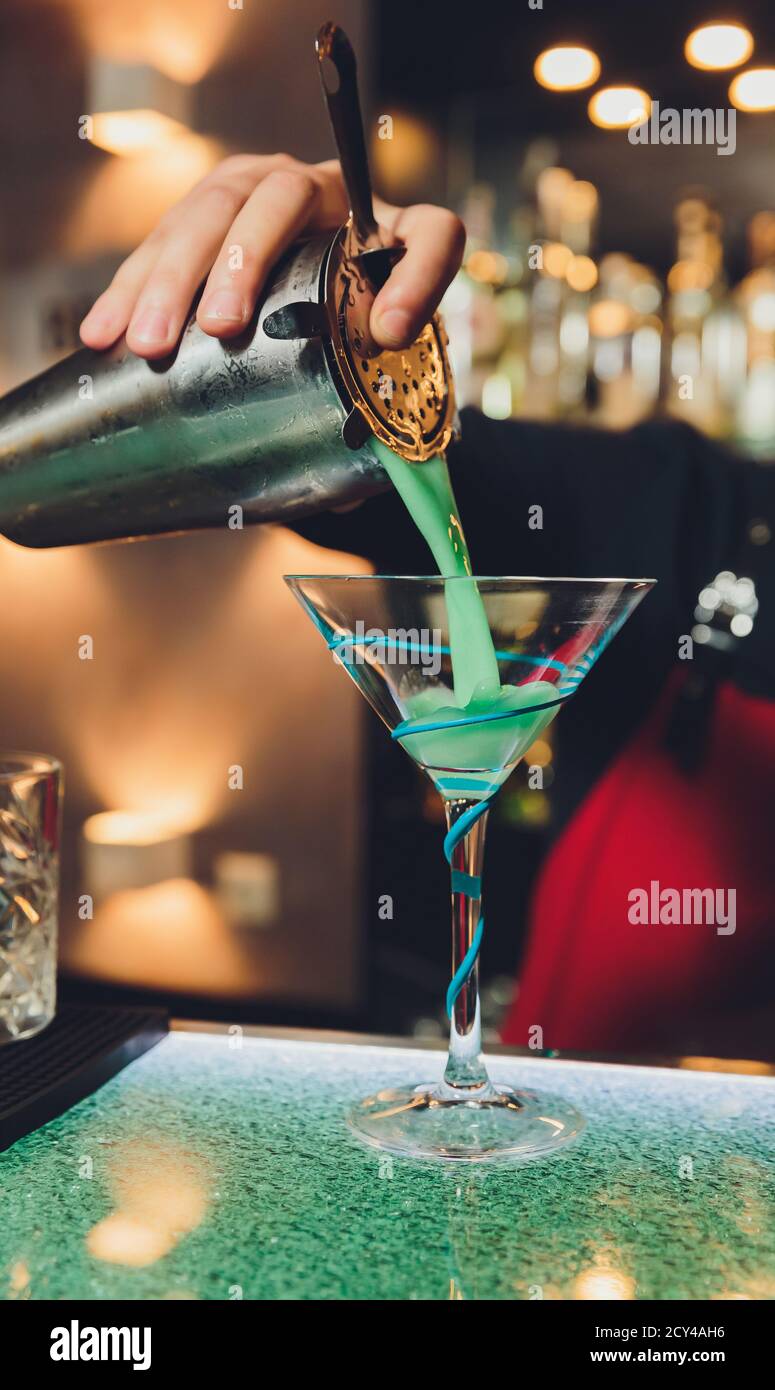 Green cocktail in modern glass on bar background Stock Photo - Alamy