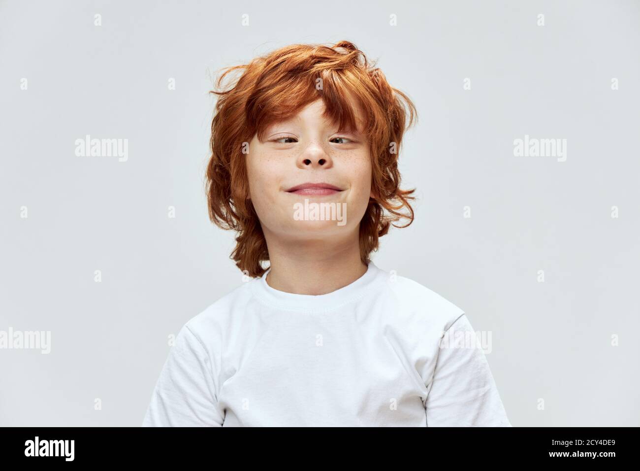Grimacing red-haired boy squinting eyes cropped view and white t-shirt ...