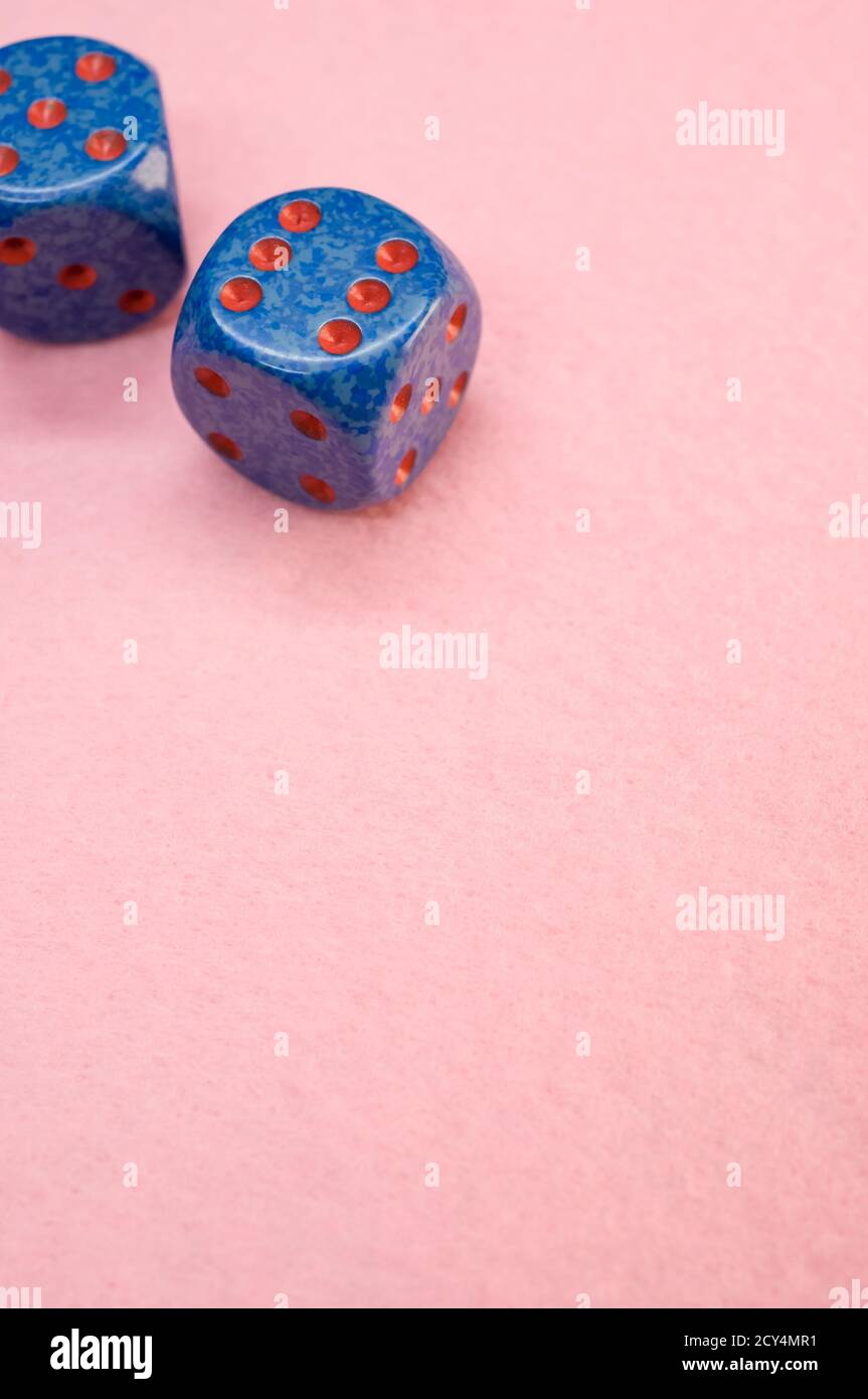 Vertical shot of blue dice on a light pink surface Stock Photo - Alamy