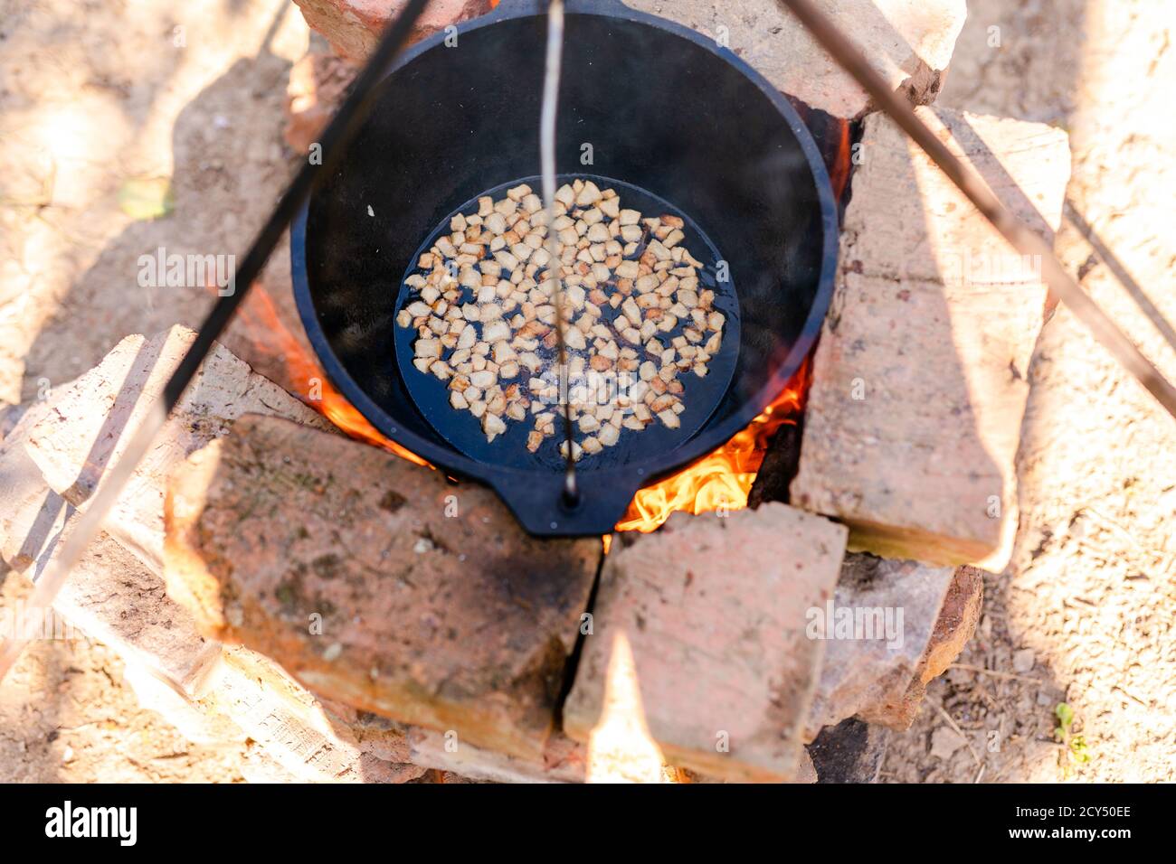 Preparation of raditional armenian pilaf in a cauldron on an open fire ...