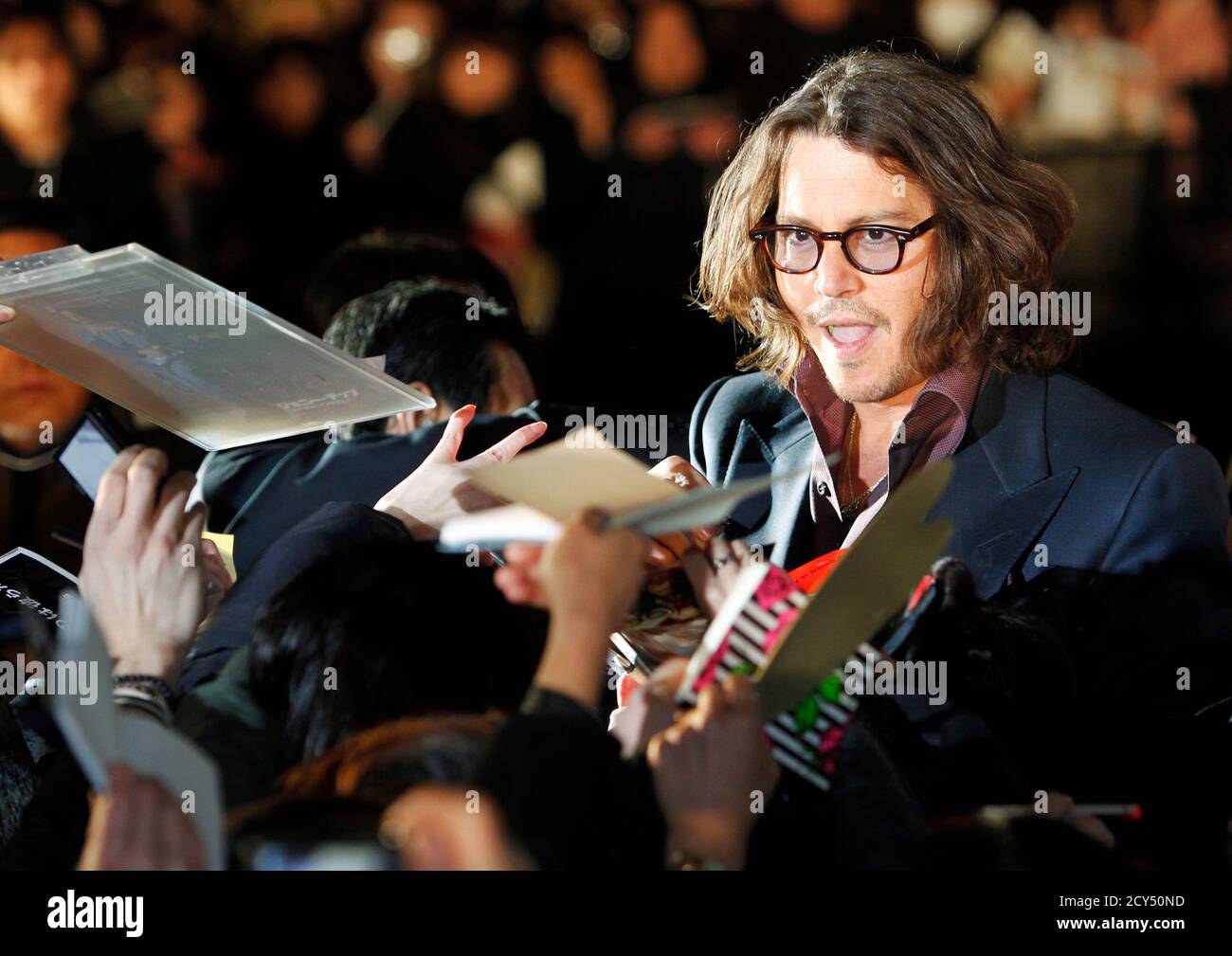 U.S. actor Johnny Depp signs autographs for fans at a red carpet event ...