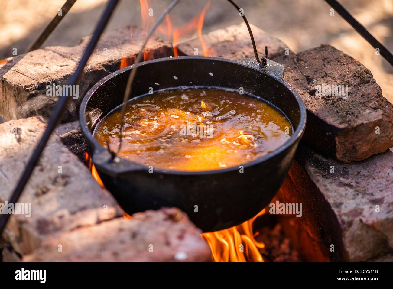 Preparation of raditional armenian pilaf in a cauldron on an open fire ...